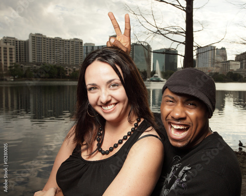 man-secretly-placing-bunny-ears-behind-the-womans-head-stock-photo