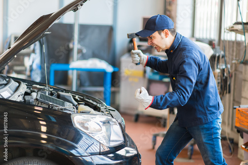"Angry mechanic smashing a car engine" Stock photo and royalty-free ...