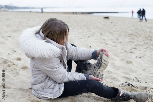 "Young Girl Taking Off Wellington Boots For Walk On Beach " Stock photo ...