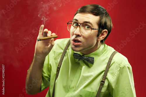 "Suspicious nerd smoking a cigar and looking at camera" Stock photo and ...