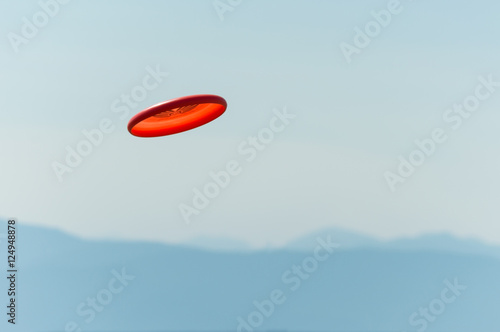 "Frisbee flying through the air with a view of the mountains in the ...