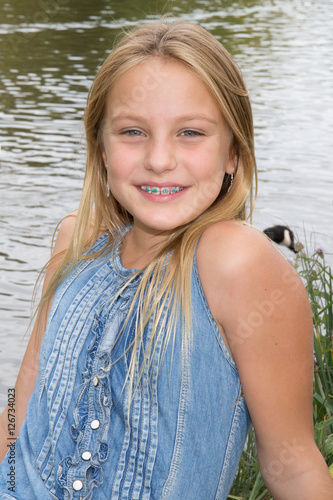 "blond preteen girl in blue dress close up summer photo on the green ...