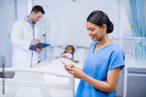 "Smiling nurse using mobile phone" Stock photo and royalty-free images ...