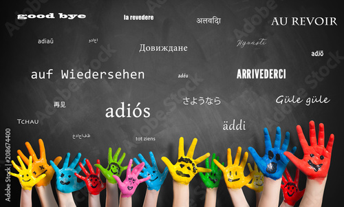 "Viele Kinderhände vor Wandtafel mit dem Wort "Auf Wiedersehen" in ...