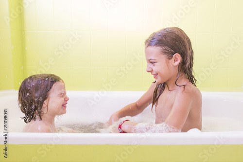 "Happy laughing sister kids taking a bath playing with foam bubbles ...