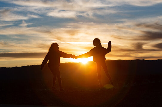Two Best Friends Holding Hands In The Sunset