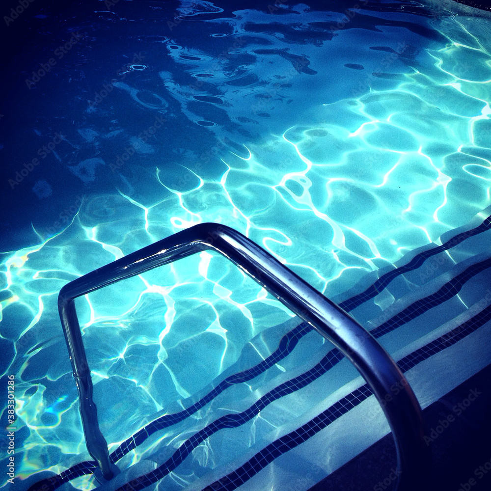 Blue reflecting water in a swimming pool with stee | WallsHeaven | Ole
