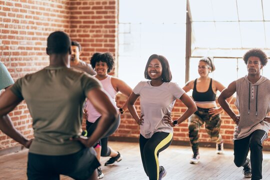 Diverse Men Exercising in Modern Gym Using Dumbbells