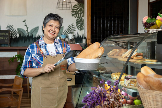Smiling Baristas Holding Desserts in Cozy Café